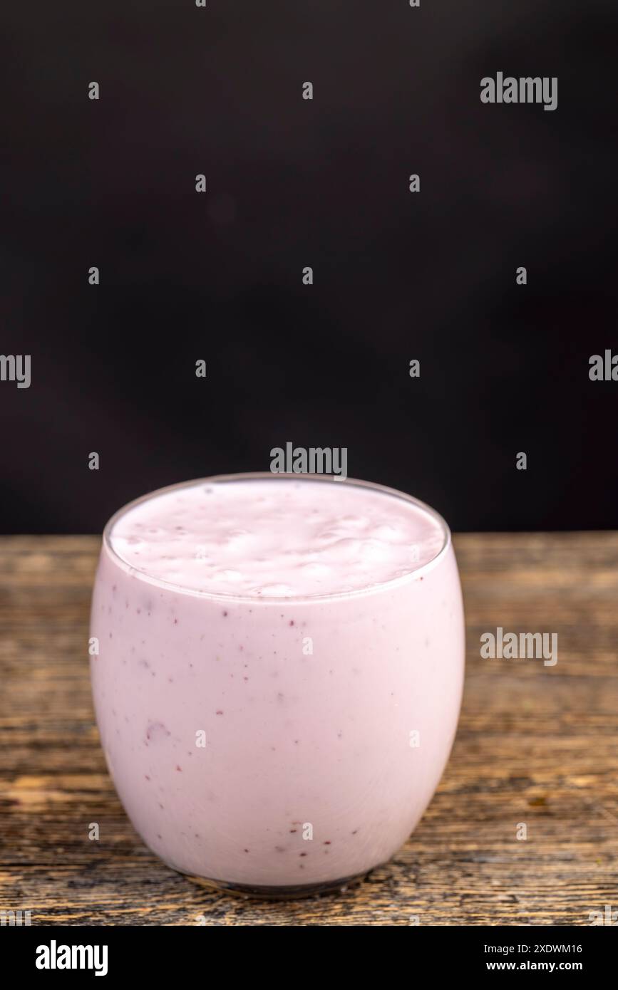 pink fermented milk drink with berry flavor, pieces of berries and ...