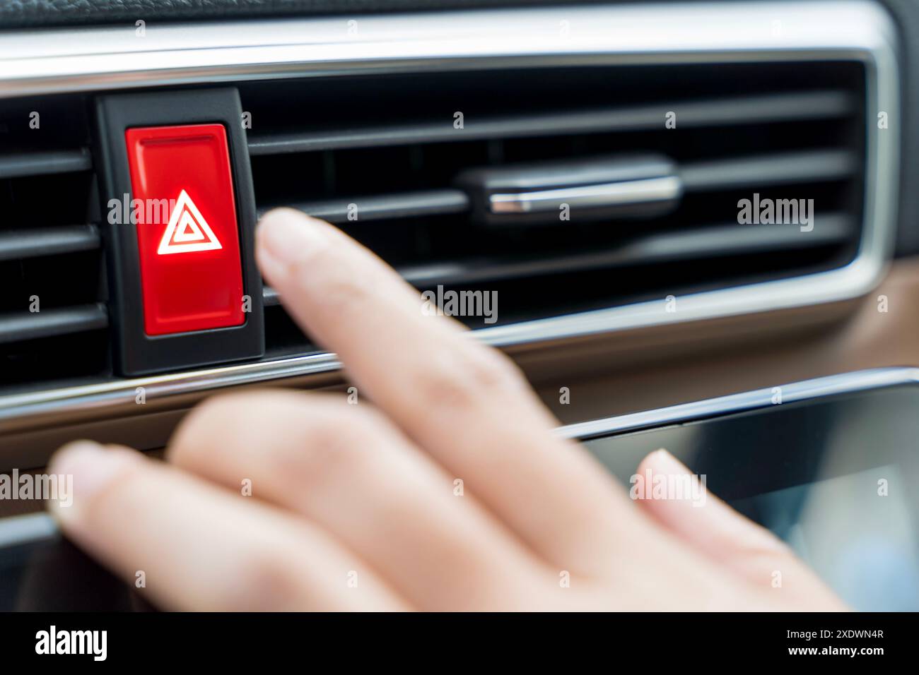 The driver is pressing the emergency stop button on the car dashboard ...