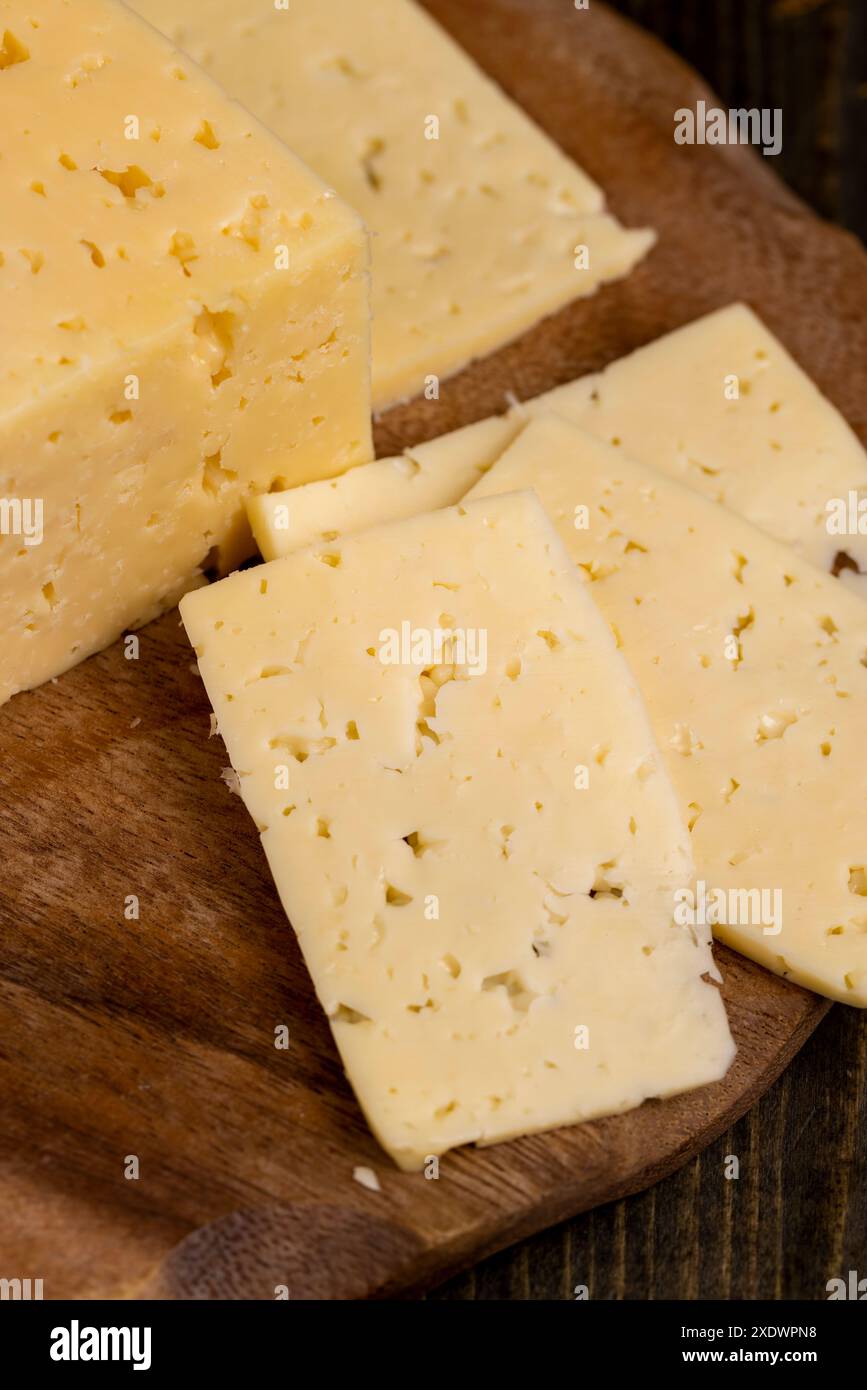 yellow hard cheese with holes, natural organic cheese products close-up ...