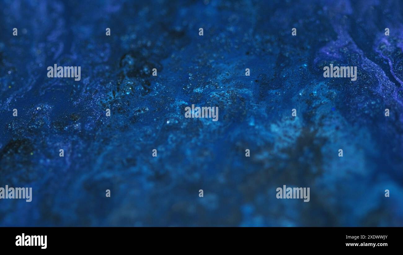 Shiny liquid. Glitter ink spill. Defocused blue color sparkling grain ...