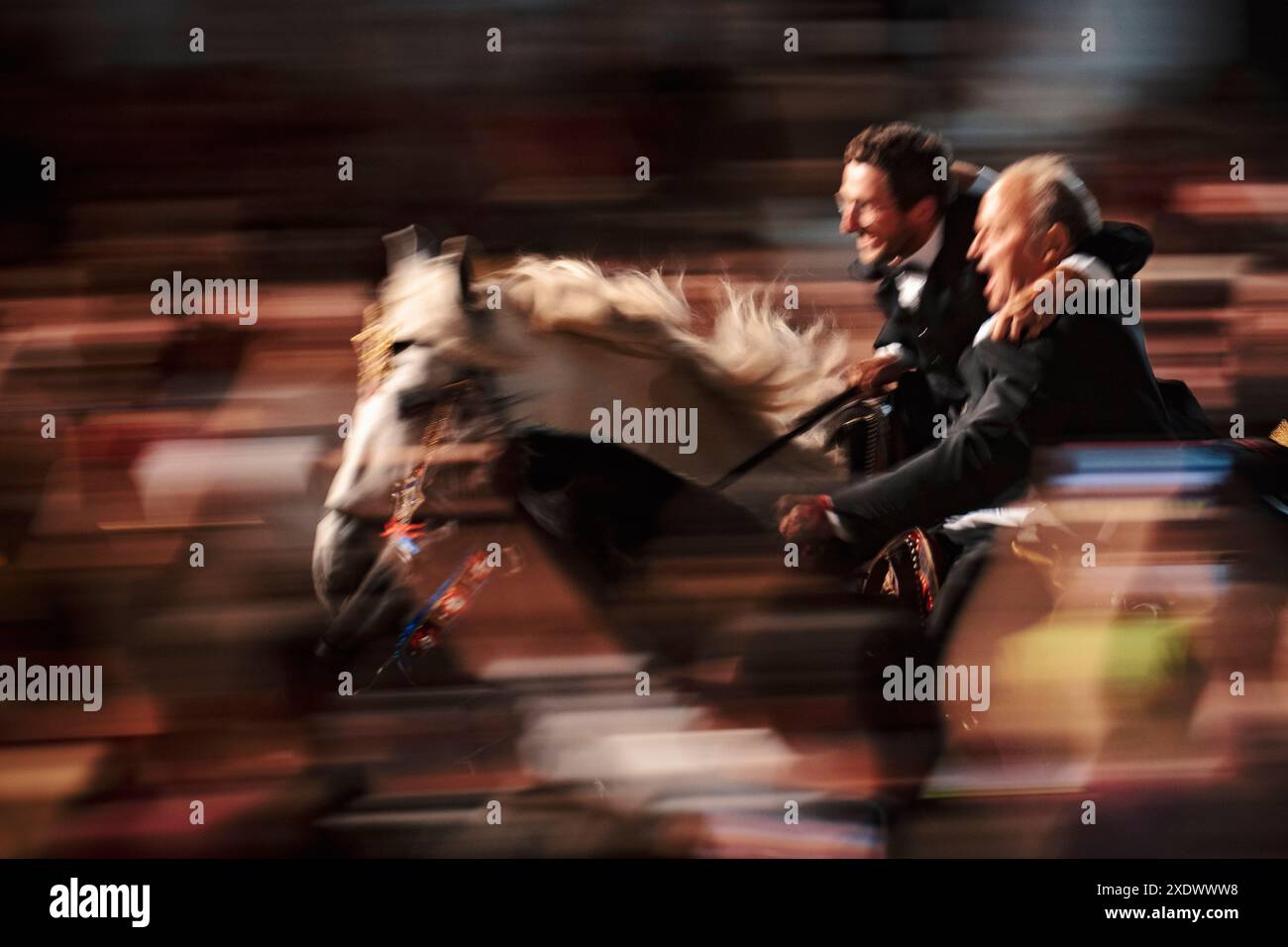 Ciutadella, Spain. 24 June, 2024: Two 'caixers' (horse riders) gallop ...