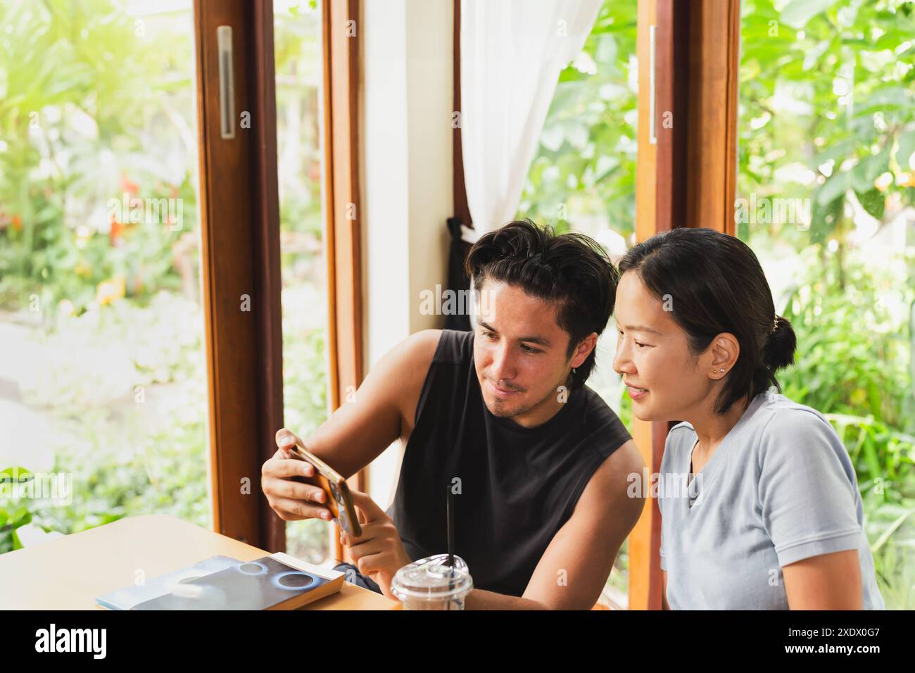 Asian family sitting together in cafe looking mobile phone Stock Photo ...
