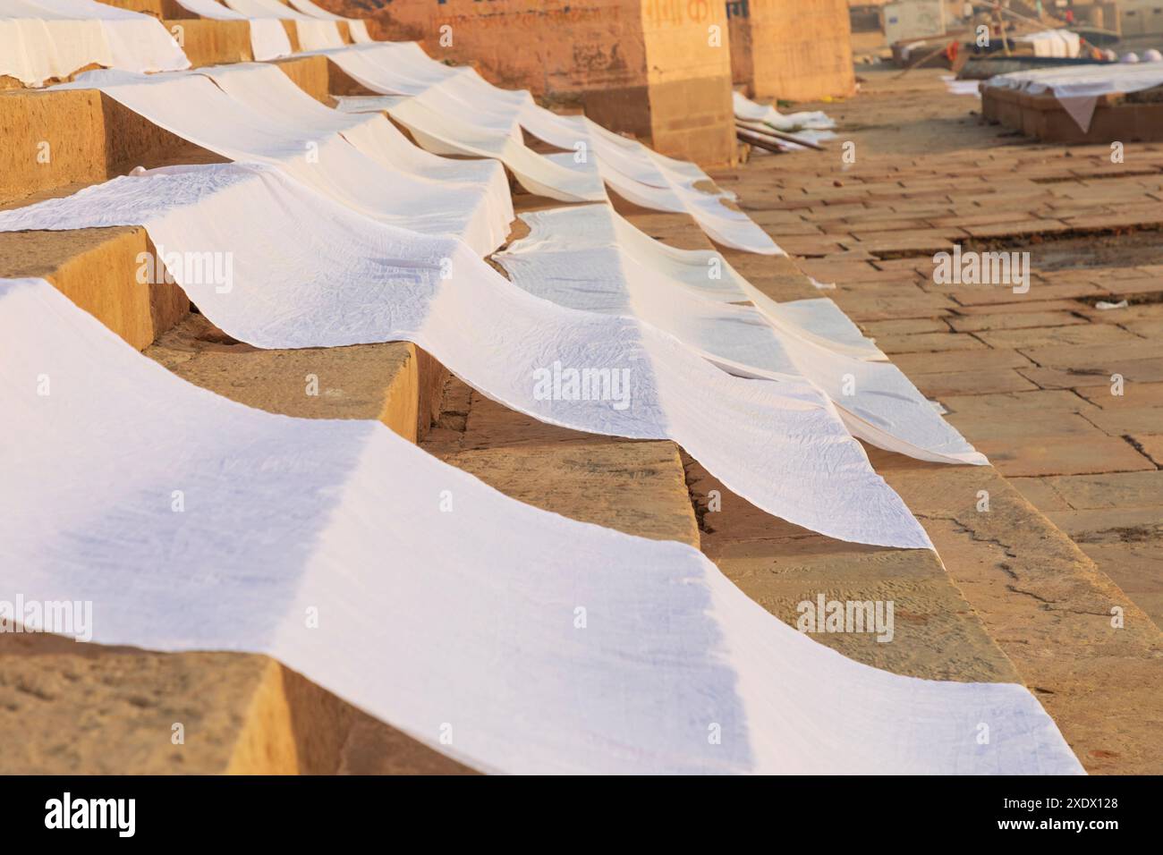India, Uttar Pradesh, Varanasi, Bangali Tola. White sheets laid out on ...