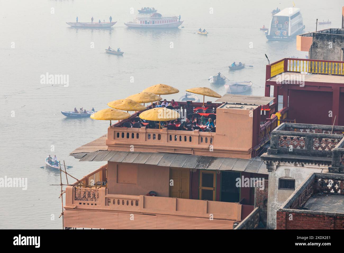 India, Uttar Pradesh, Varanasi. People dining on a rooftop overlooking ...
