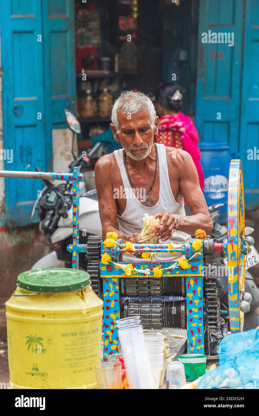 India, West Bengal, Kolkata, College Square. Man grinding sugar cane to ...