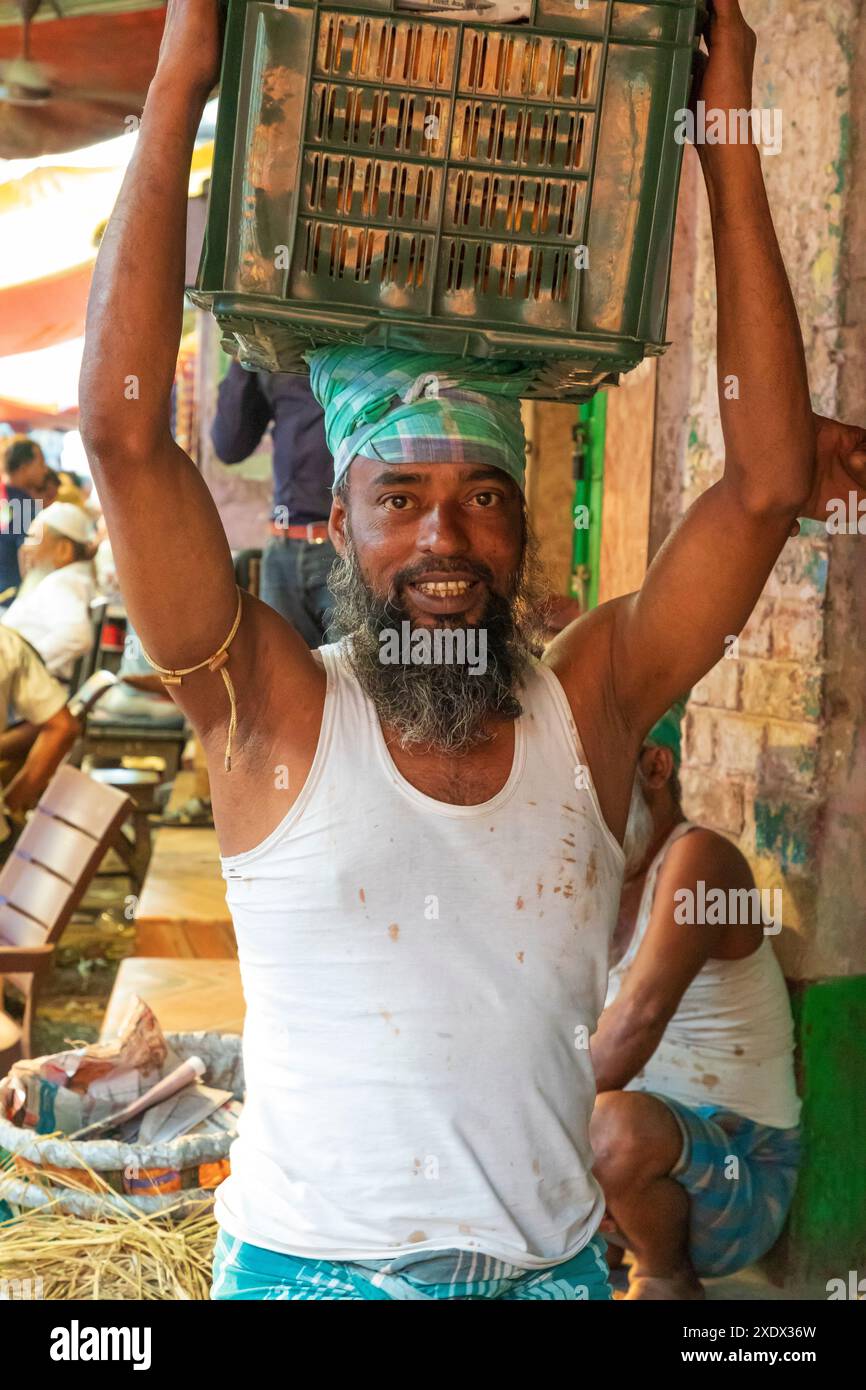India, West Bengal, Kolkata, Jorasanko. Portrait of a man carrying a ...