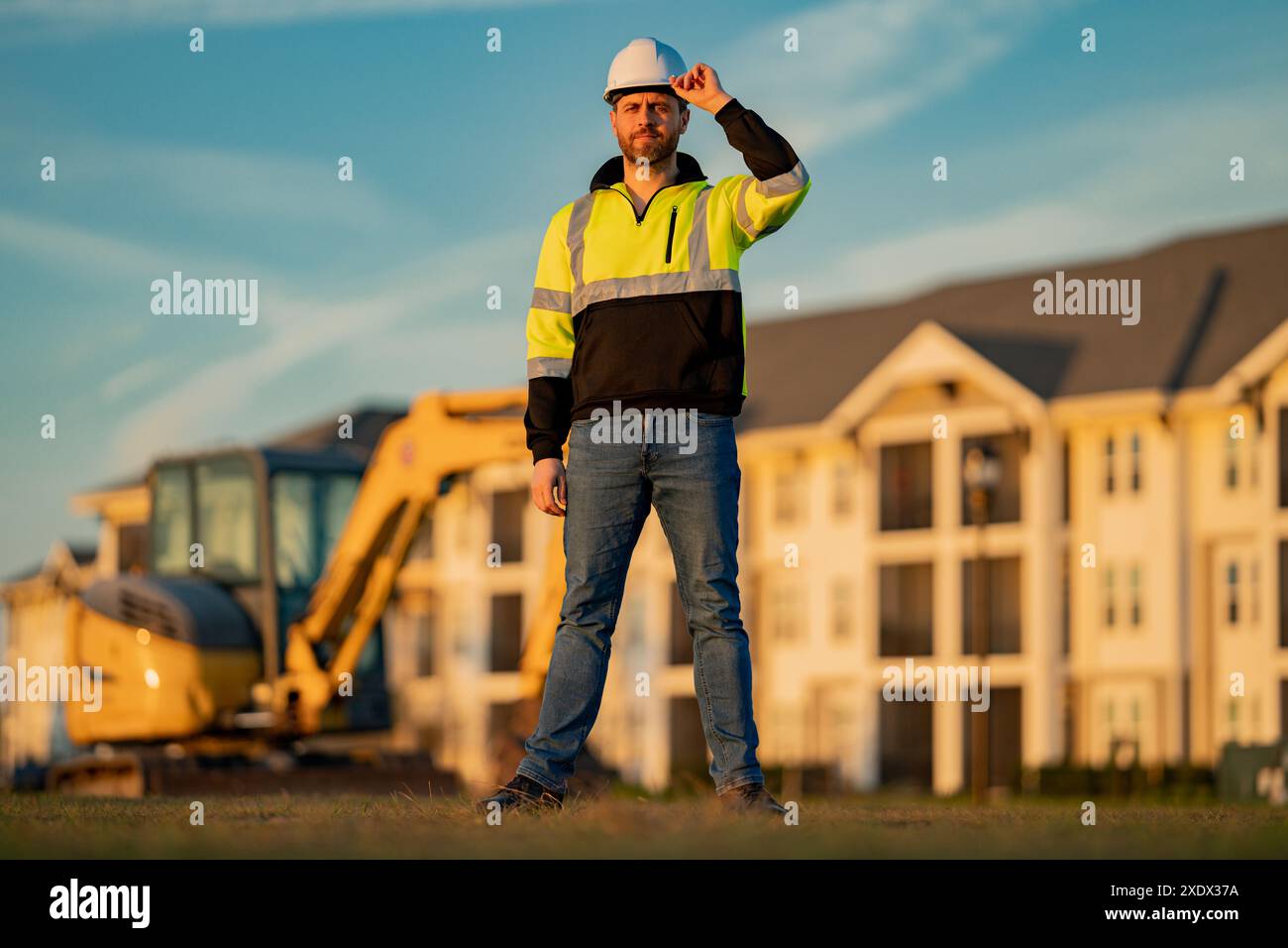 Builder in a construction site. Builder with excavator ready to build ...
