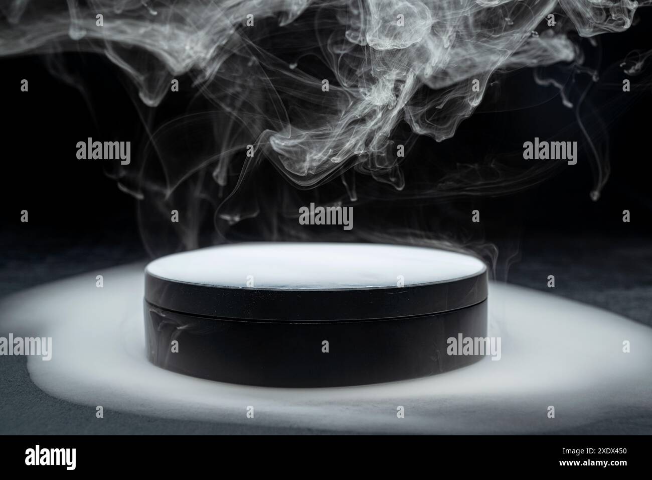 Round platform emerging from a mysterious dry ice smoke on a black ...
