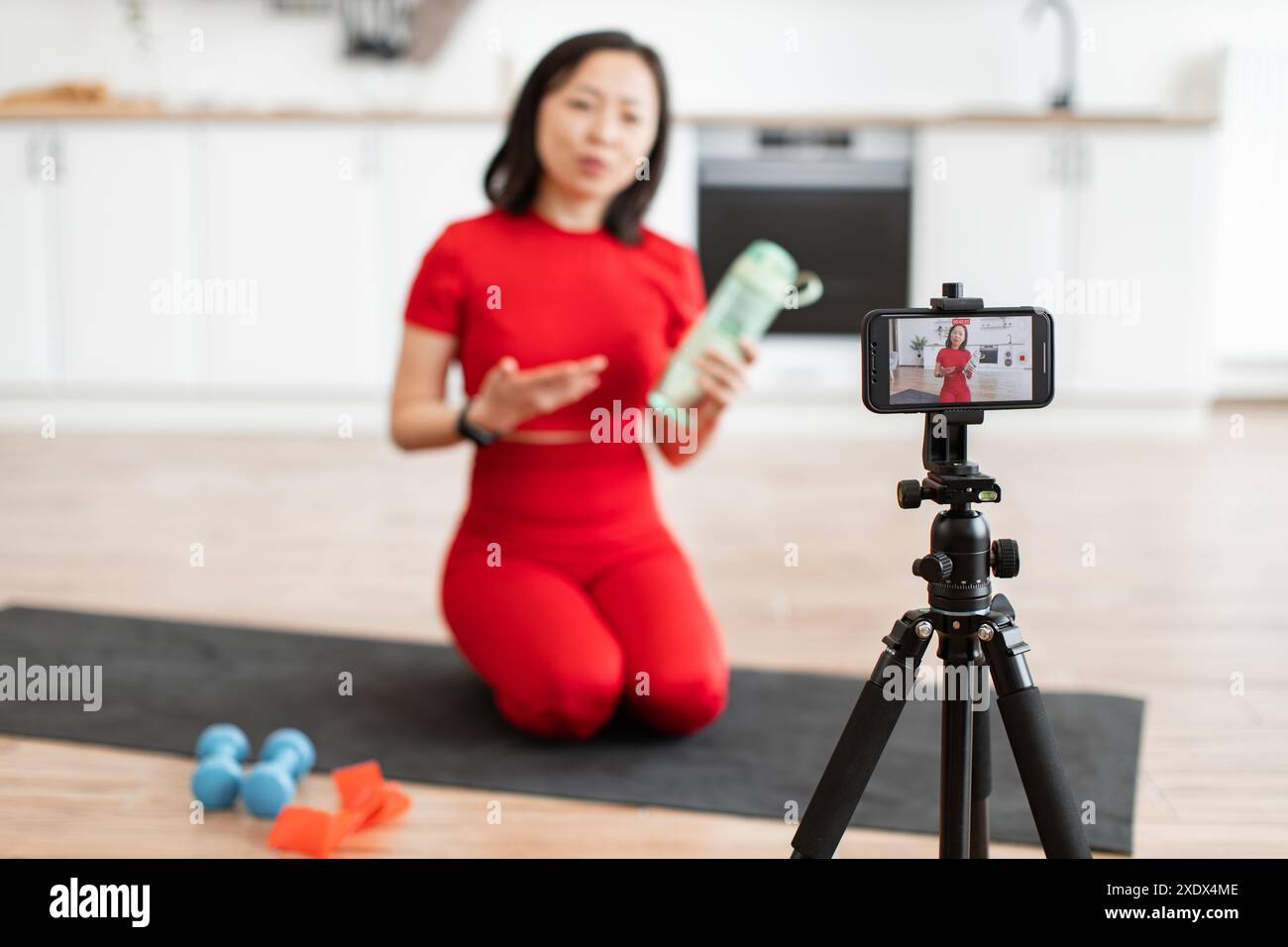 Woman recording fitness tutorial at home with smartphone Stock Photo ...