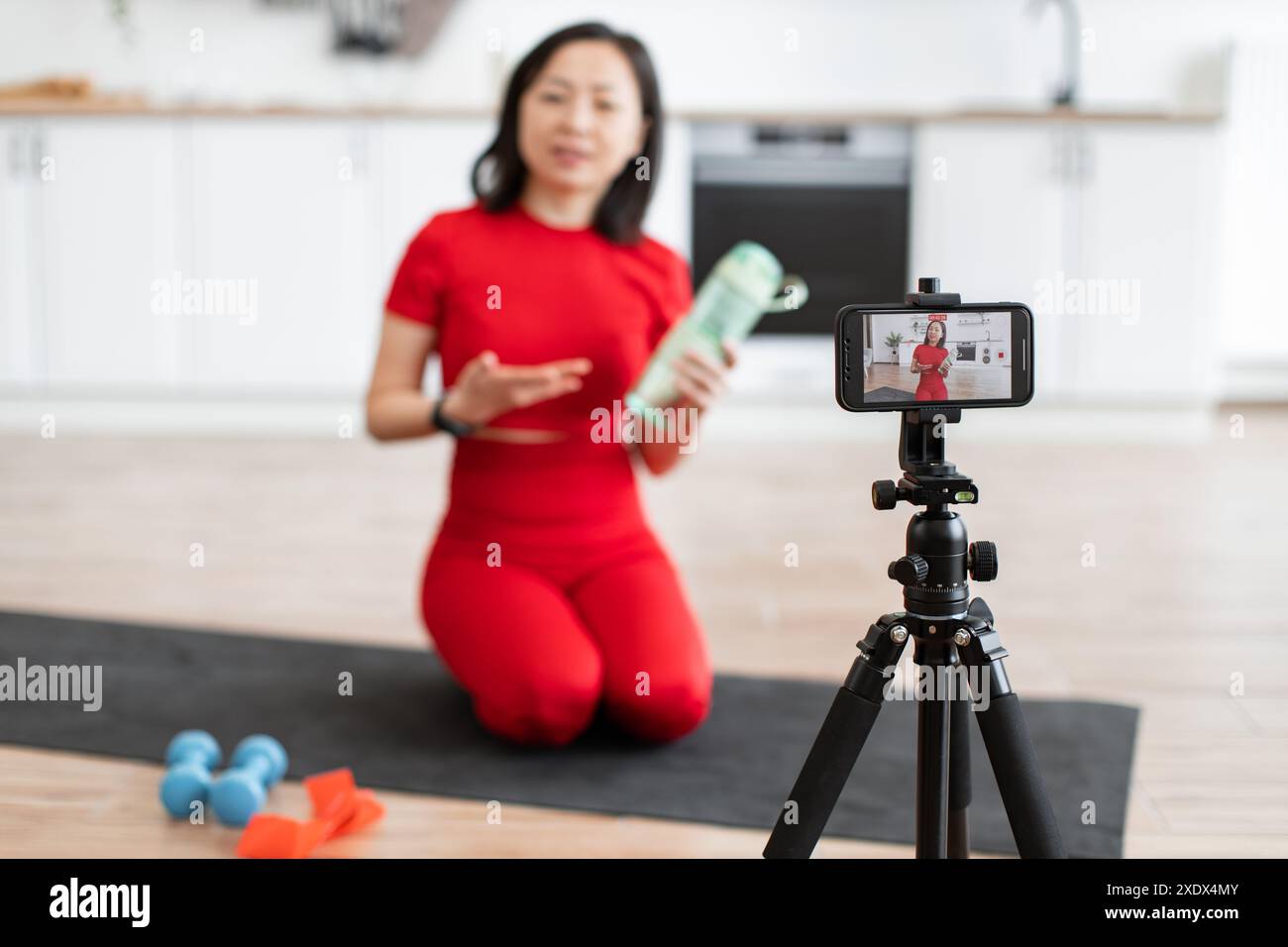 Fitness influencer filming online workout tutorial at home Stock Photo ...