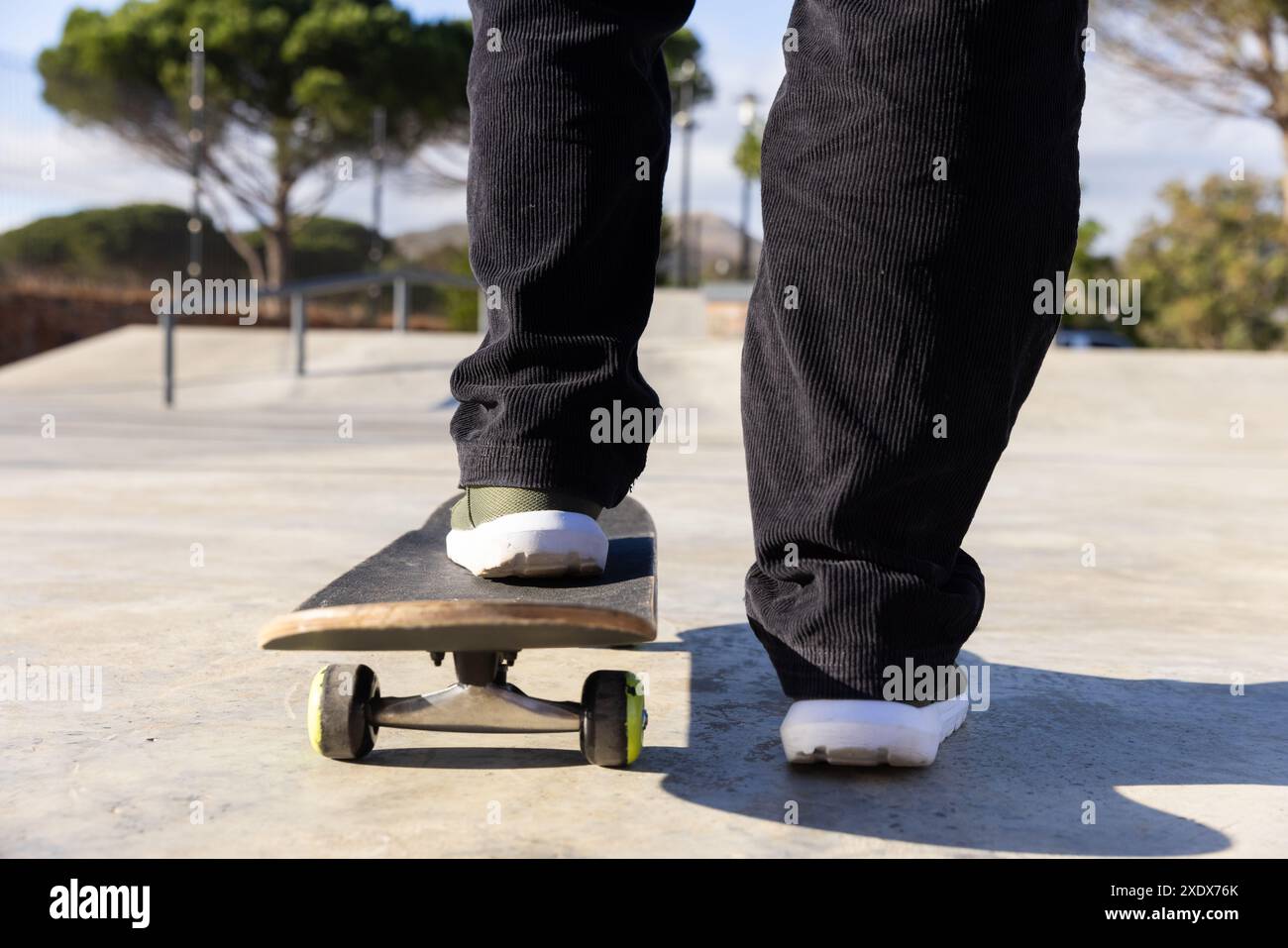 Skateboarding at park, male student balancing on skateboard, enjoying ...