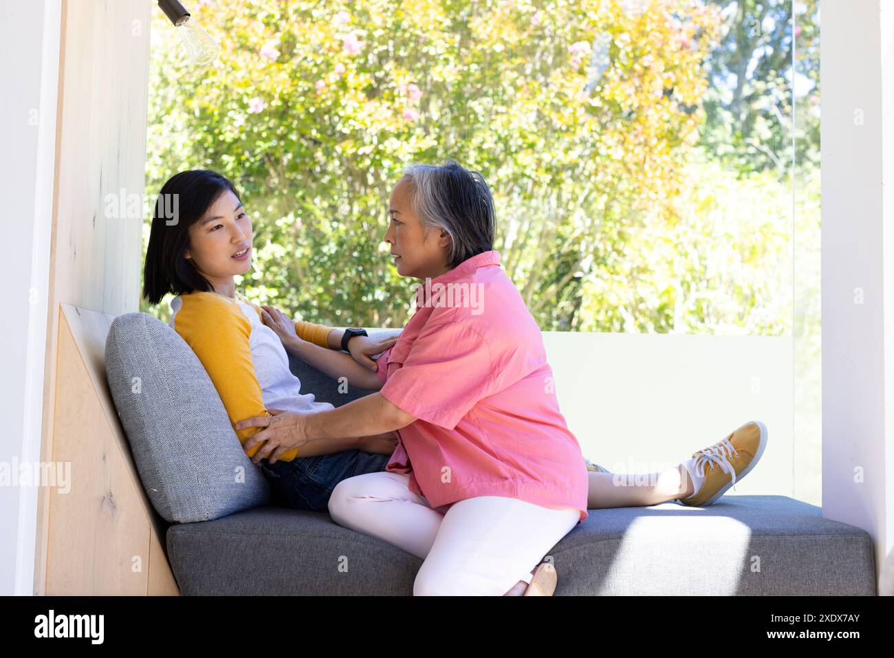 Mother supporting daughter during physical therapy session at home ...