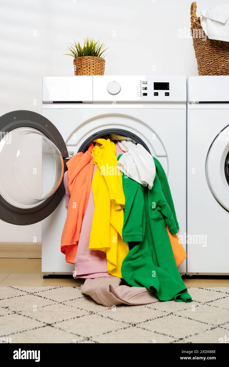 White Laundry Appliances With Colorful Clothes Overflowing From Washing ...