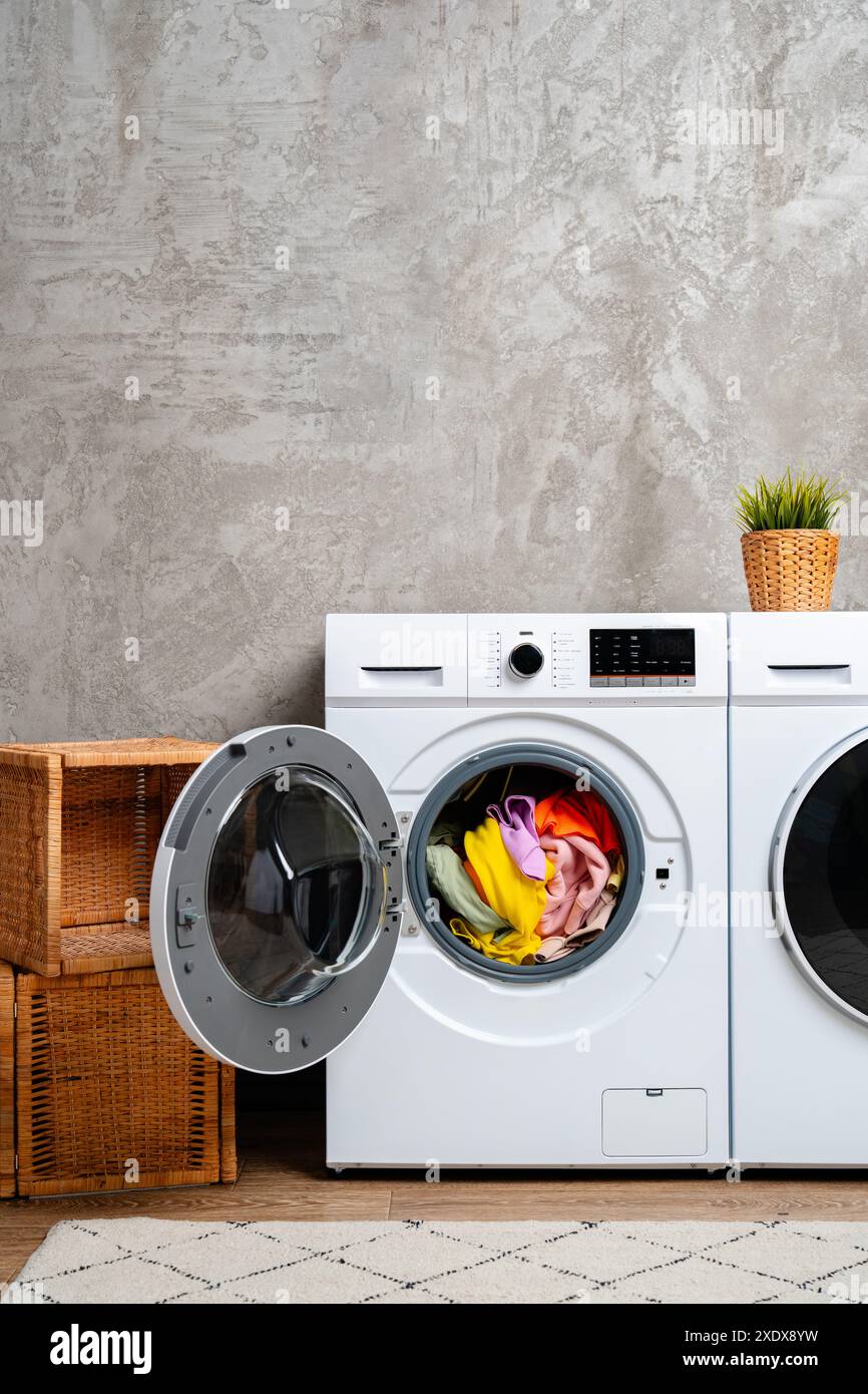 White Laundry Machines Against a Grey Concrete Wall Stock Photo - Alamy