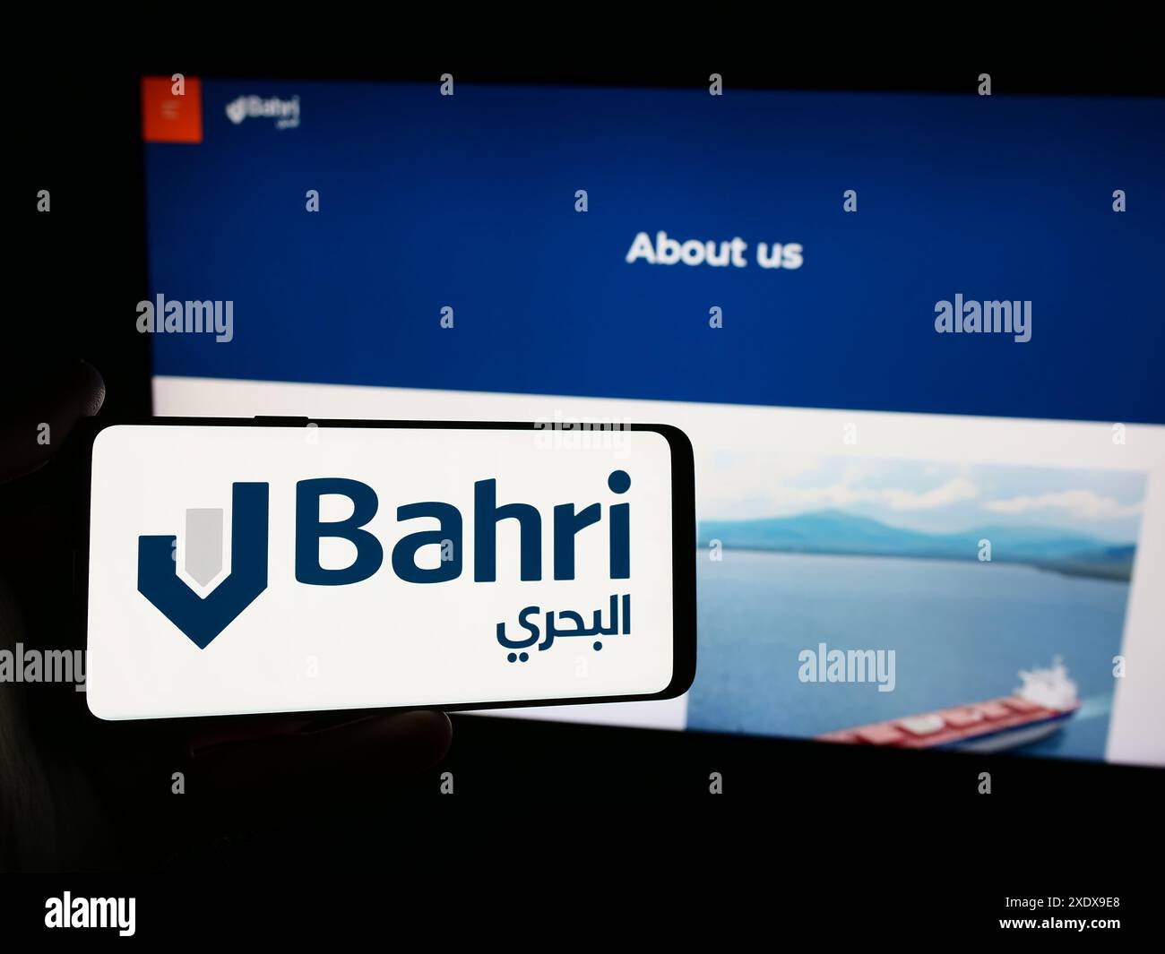 Person holding mobile phone with logo of business National Shipping ...