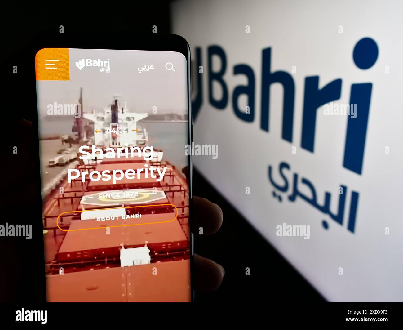 Person holding cellphone with webpage of business National Shipping ...