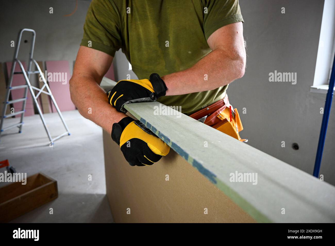 Construction worker carefully cutting drywall using a utility knife ...