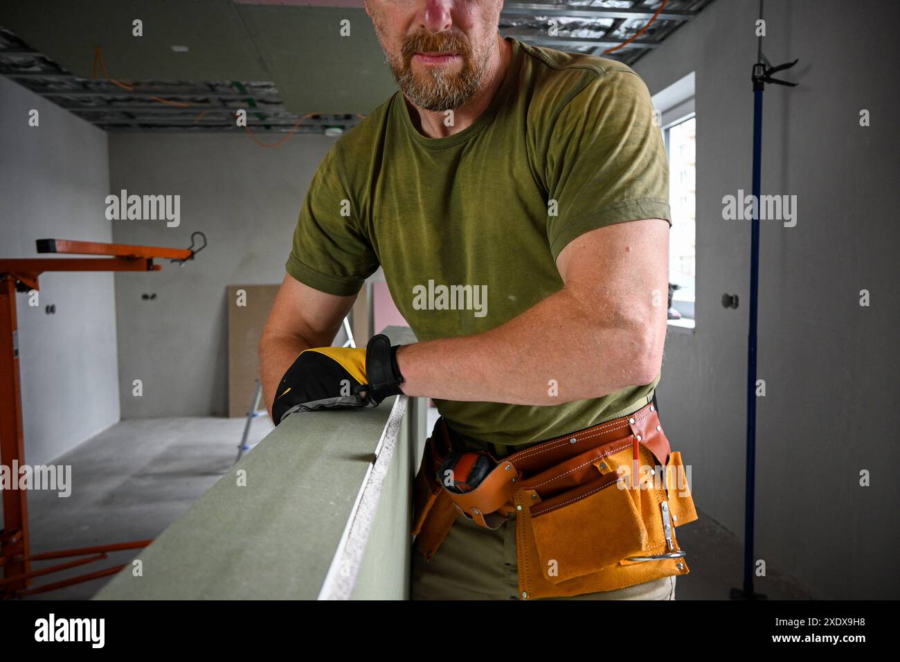 Construction worker carefully cutting drywall using a utility knife ...