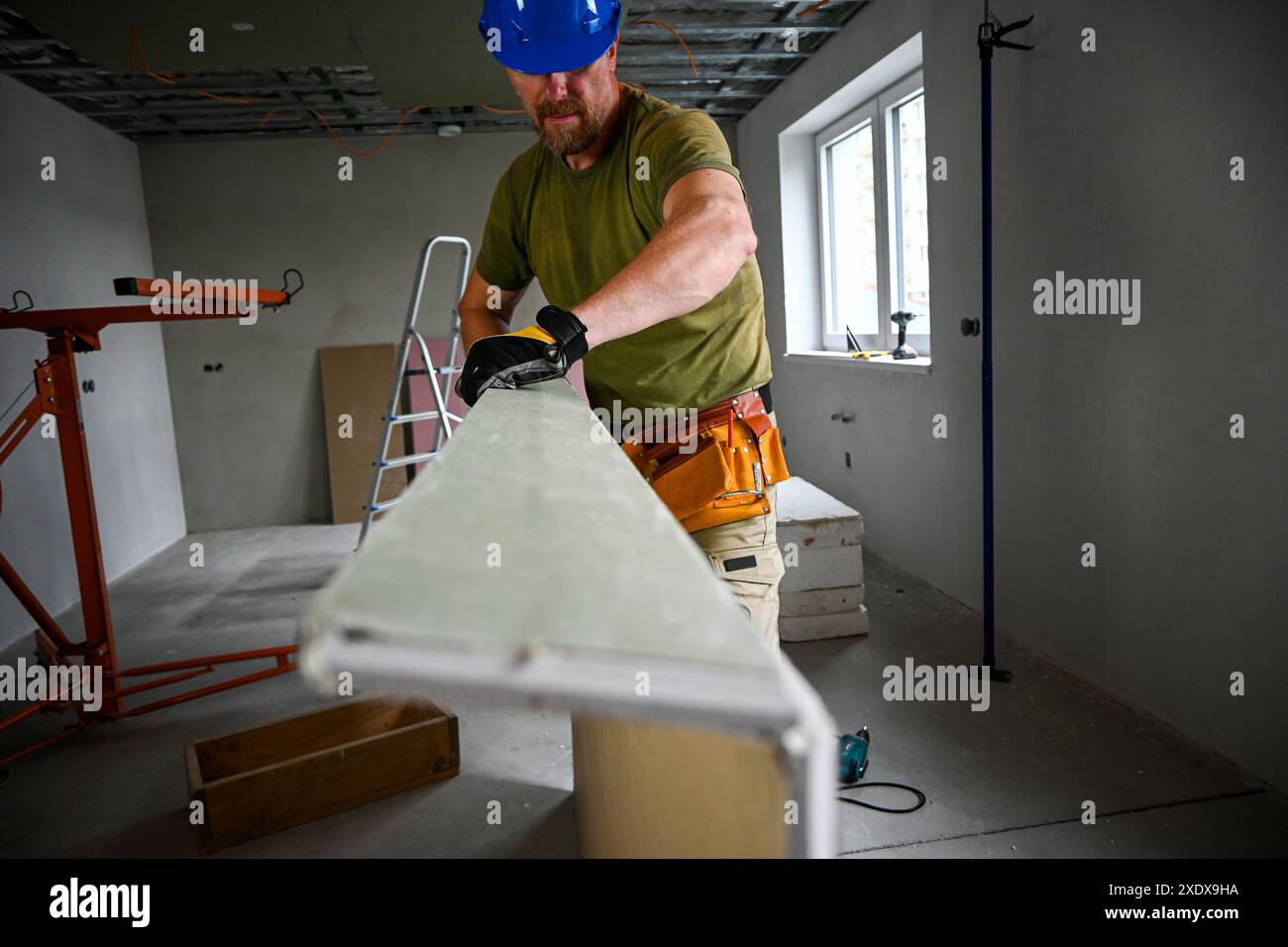 Construction worker carefully cutting drywall using a utility knife ...