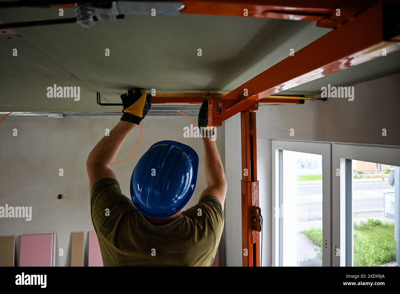 Construction worker wearing protective gear using measuring tape on ...