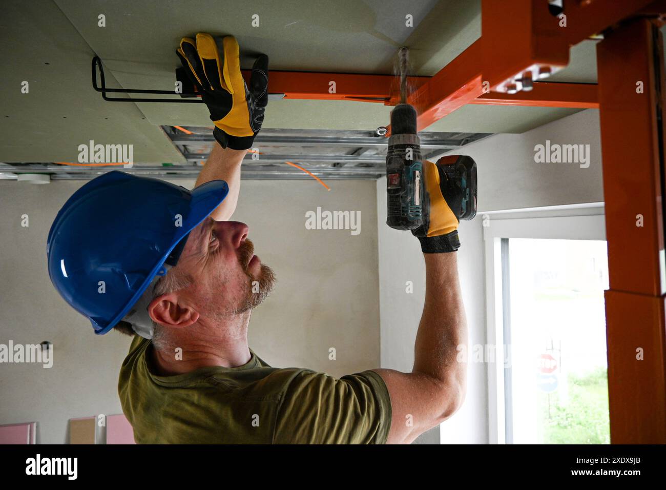 Construction worker wearing a hardhat and safety glasses using a ...