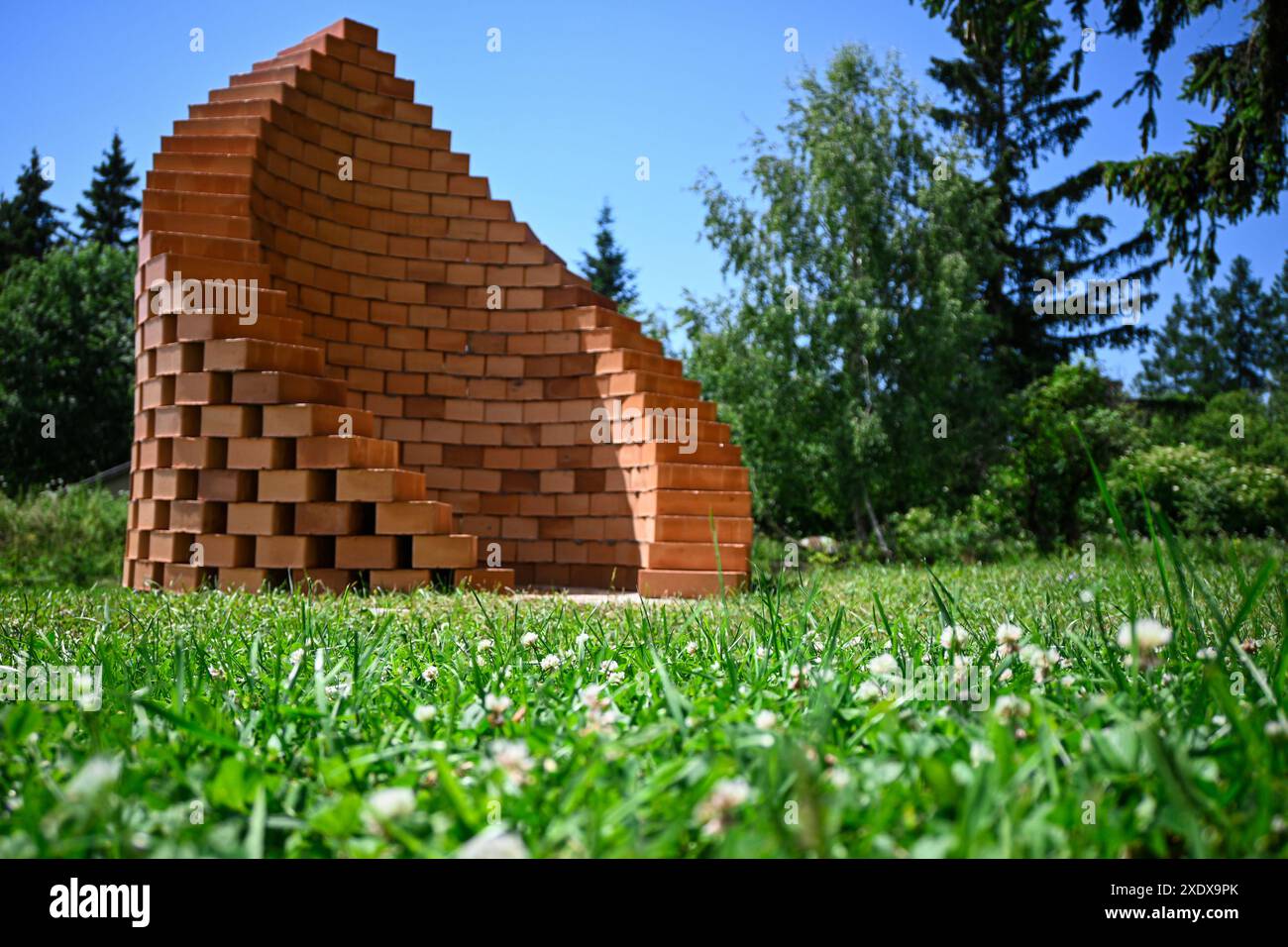 A spiral of bricks standing in a grassy field, creating a unique ...