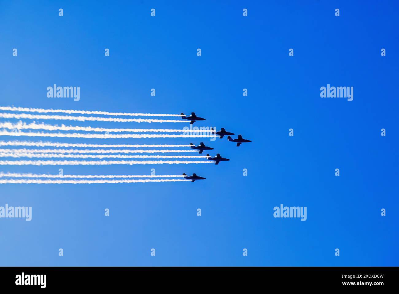 Aircrafts in formation flight with white condensation trails on a blue ...