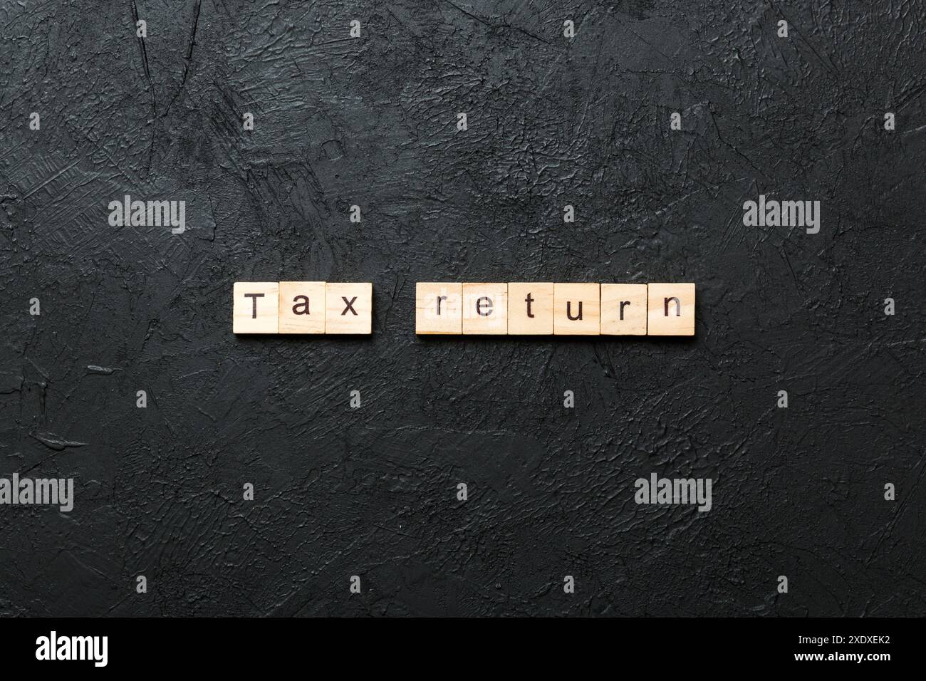 tax return word written on wood block. tax return text on cement table ...