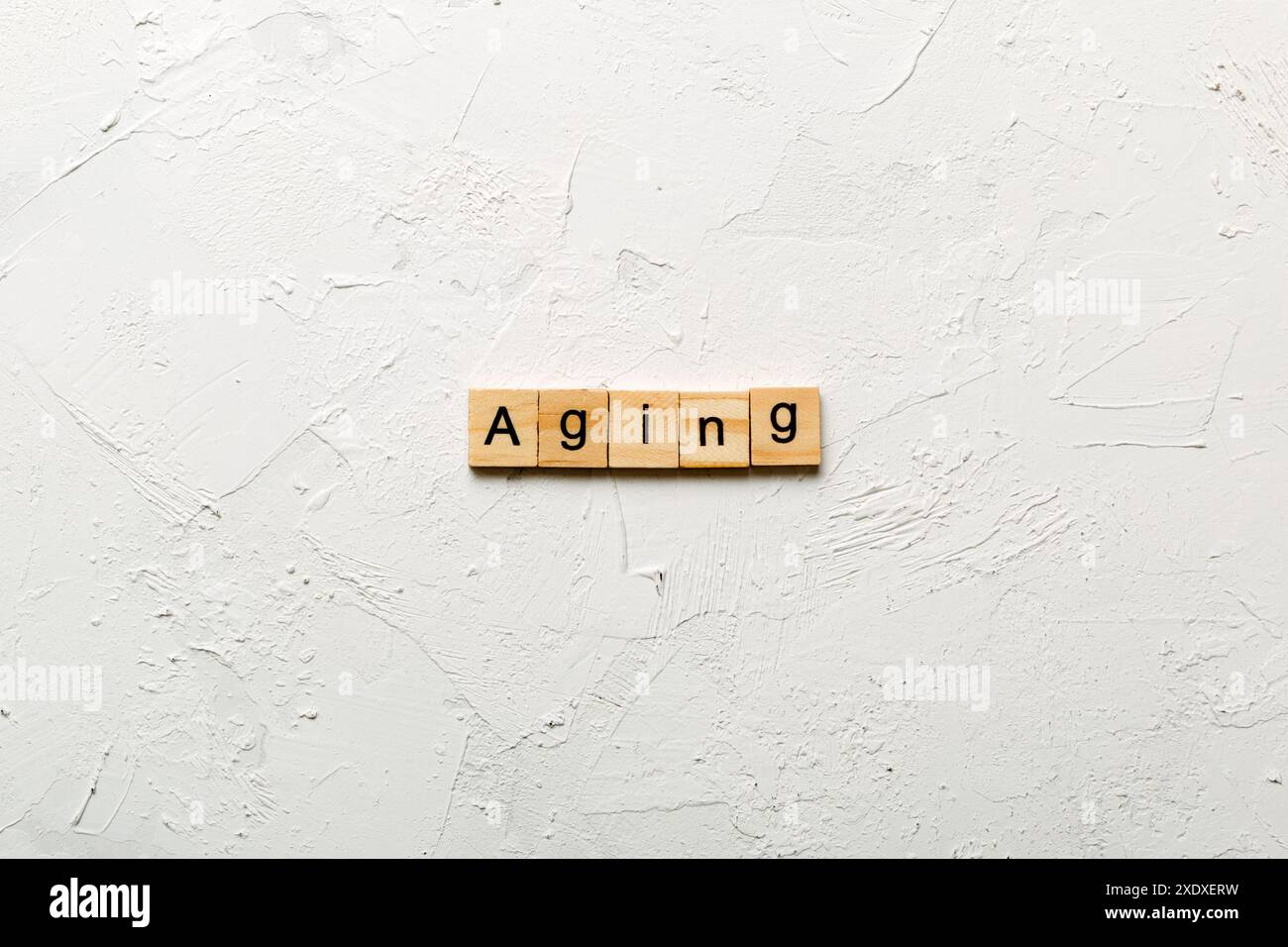 Aging word written on wood block. Aging text on cement table for your ...