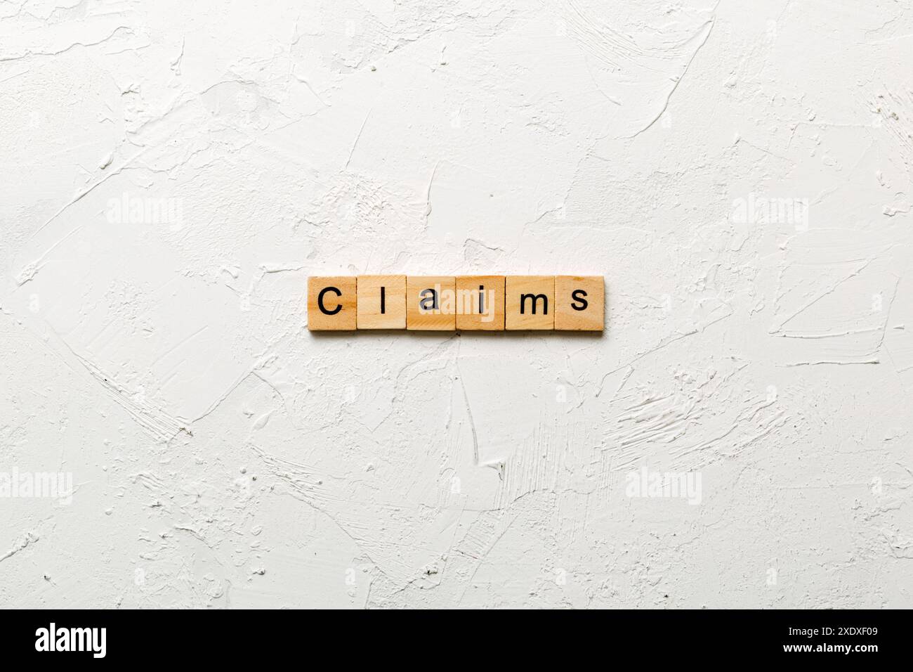 claims word written on wood block. claims text on cement table for your ...