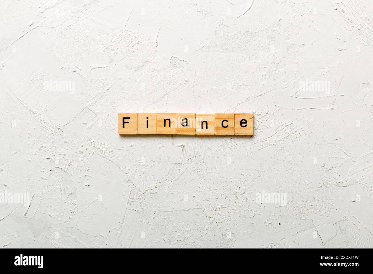 FINANCE word written on wood block. FINANCE text on cement table for ...