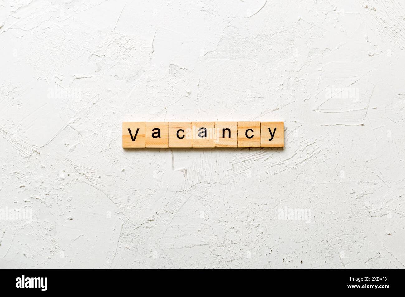 Vacancy word written on wood block. Vacancy text on cement table for ...