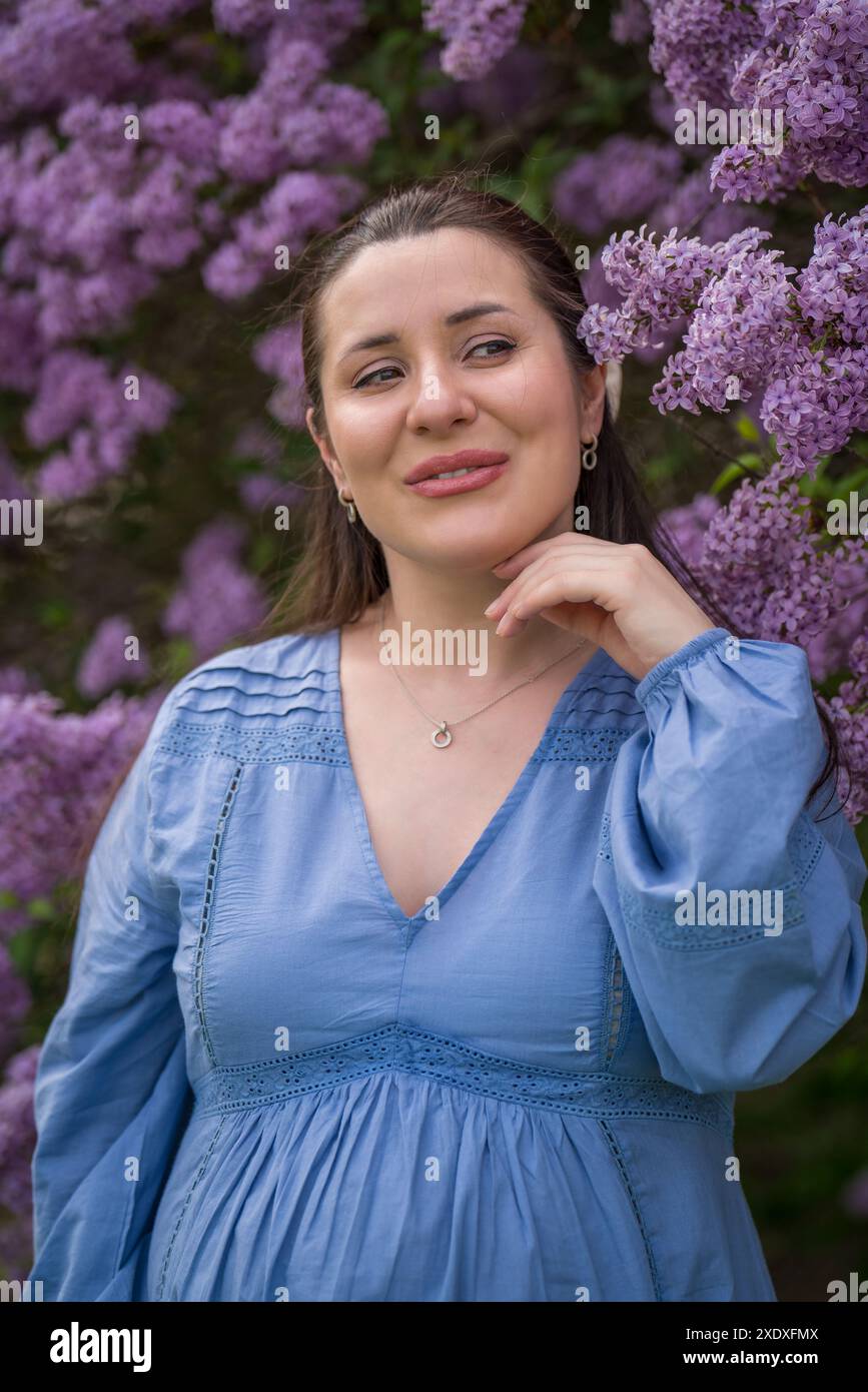 Portrait Of A Cute Happy Girl Pregnant Woman Near Lilac Close Up Pregnancy Waiting For The
