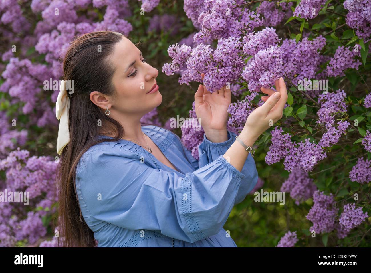Portrait of a cute, happy girl. pregnant woman near lilac. Close-up ...