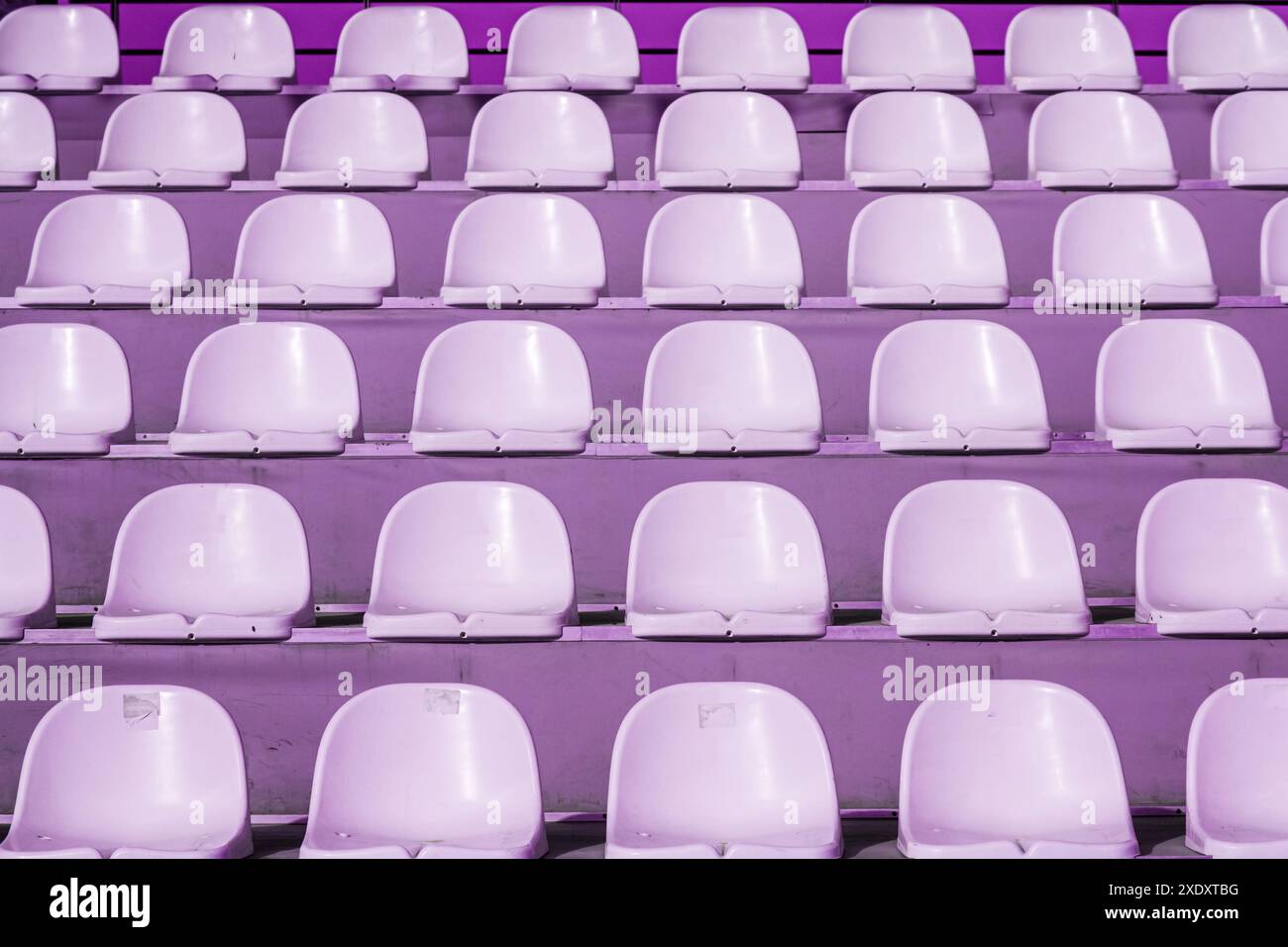 Empty rows of purple stadium seats in an outdoor setting, texture ...