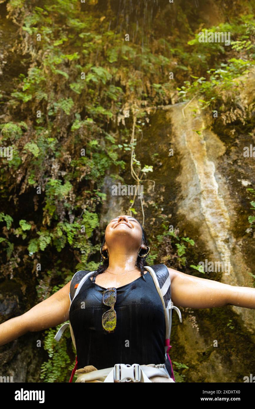 A woman stands with her arms outstretched, enjoying the refreshing ...