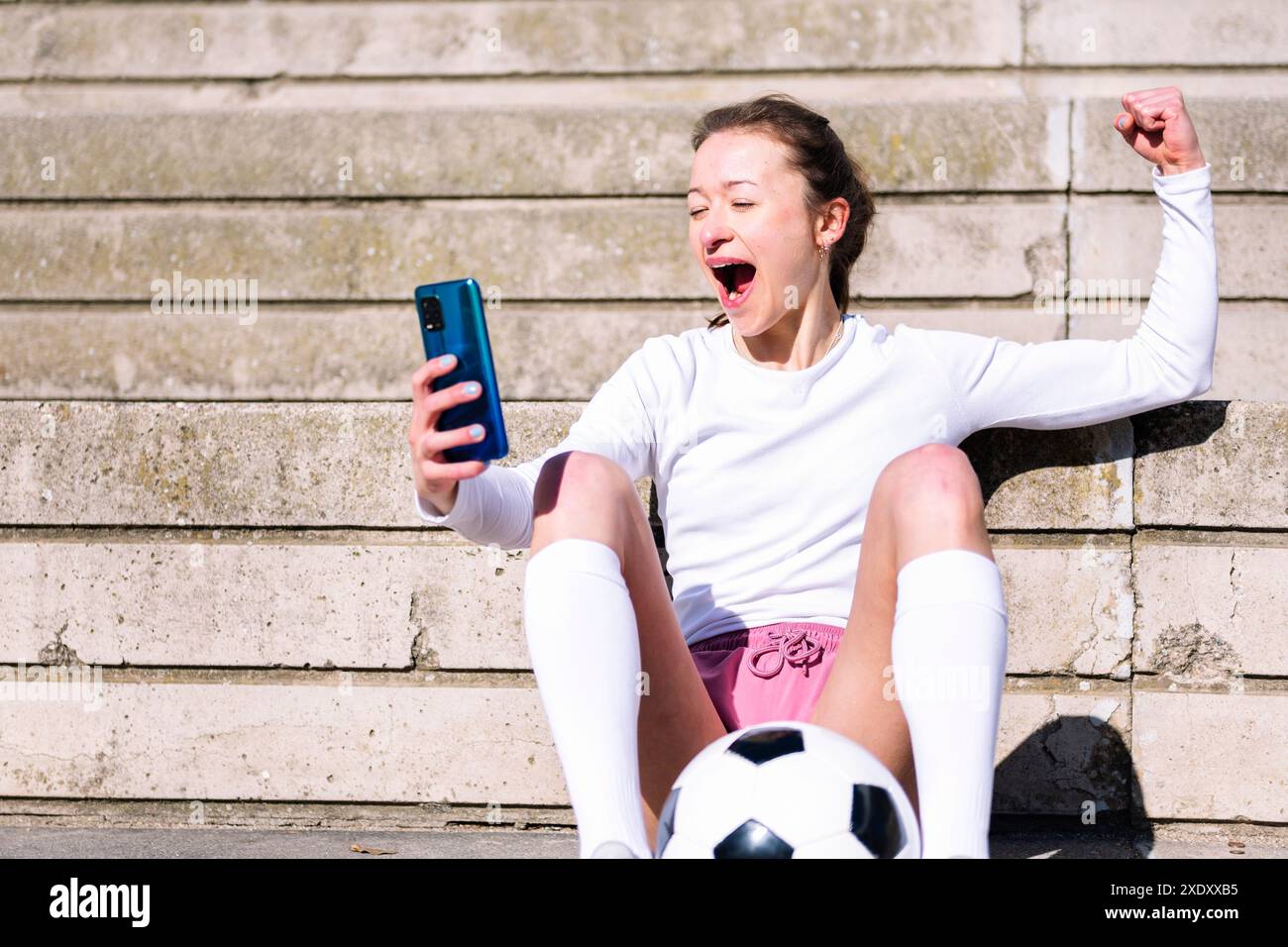 football fan celebrates victory watching phone Stock Photo - Alamy