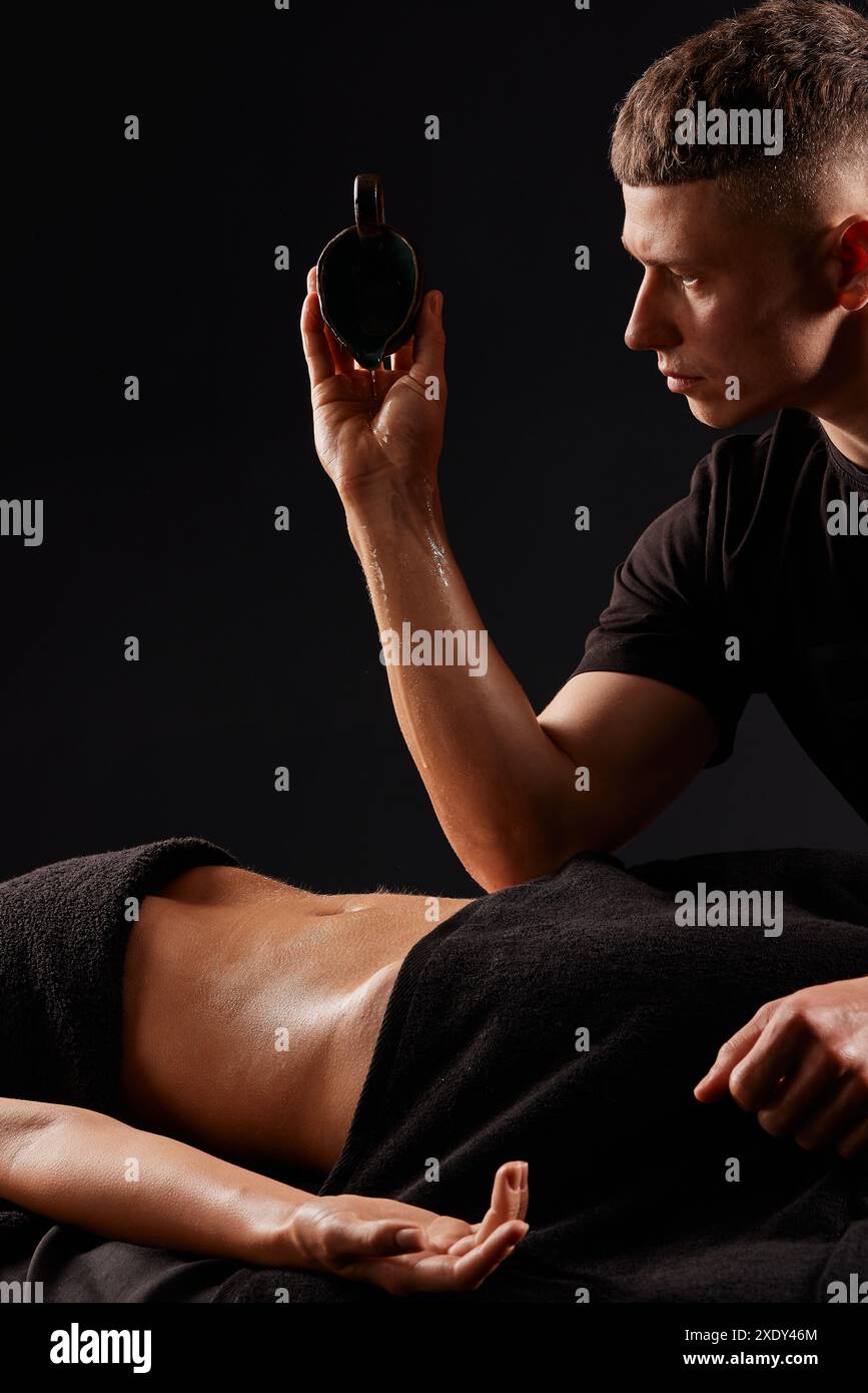 a male masseur massages a girls belly on a dark background, Abdominal ...