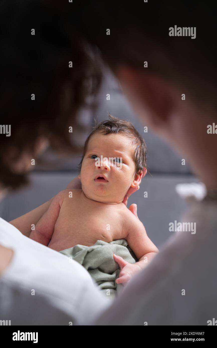 Happy family with a newborn baby. Mom and dad looking tenderly at the ...