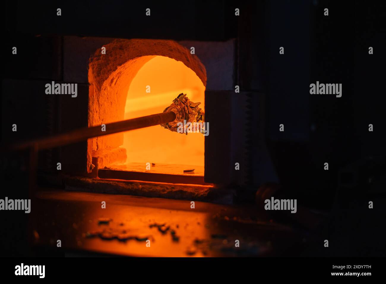 Open furnace of a glass blowing workshop with molten glass on a ...