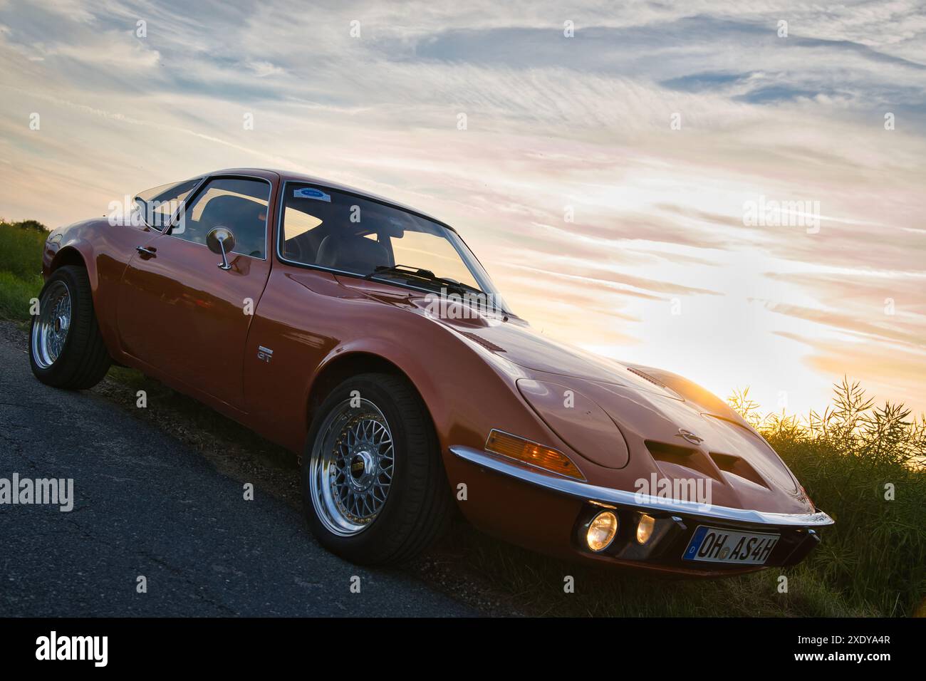 Orange Opel GT oldtimer car in a beautiful sunset with a blue cloudy ...