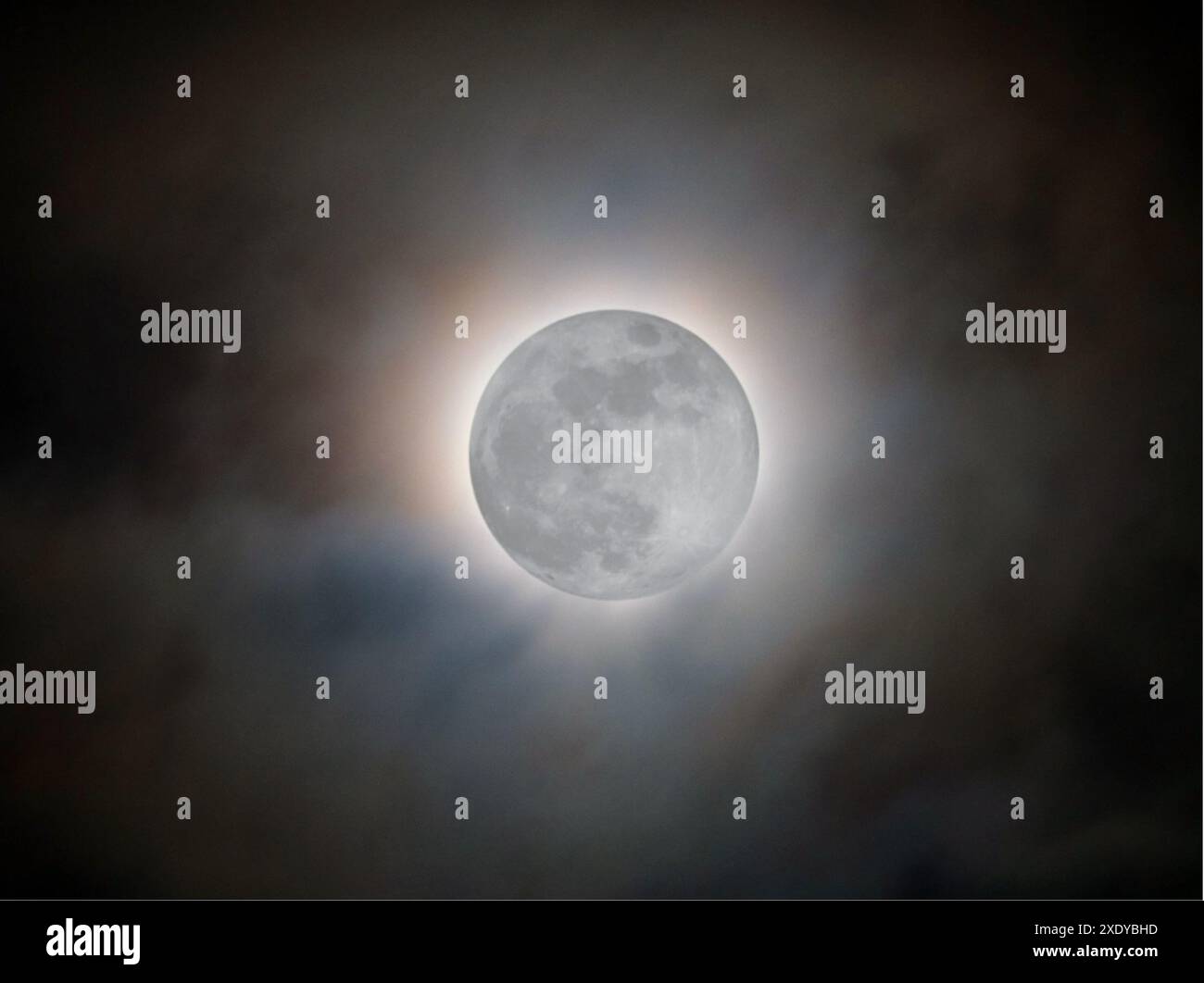 Bright blue glowing full moon surrounded by clouds in a in a dark winter sky Stock Photo - Alamy