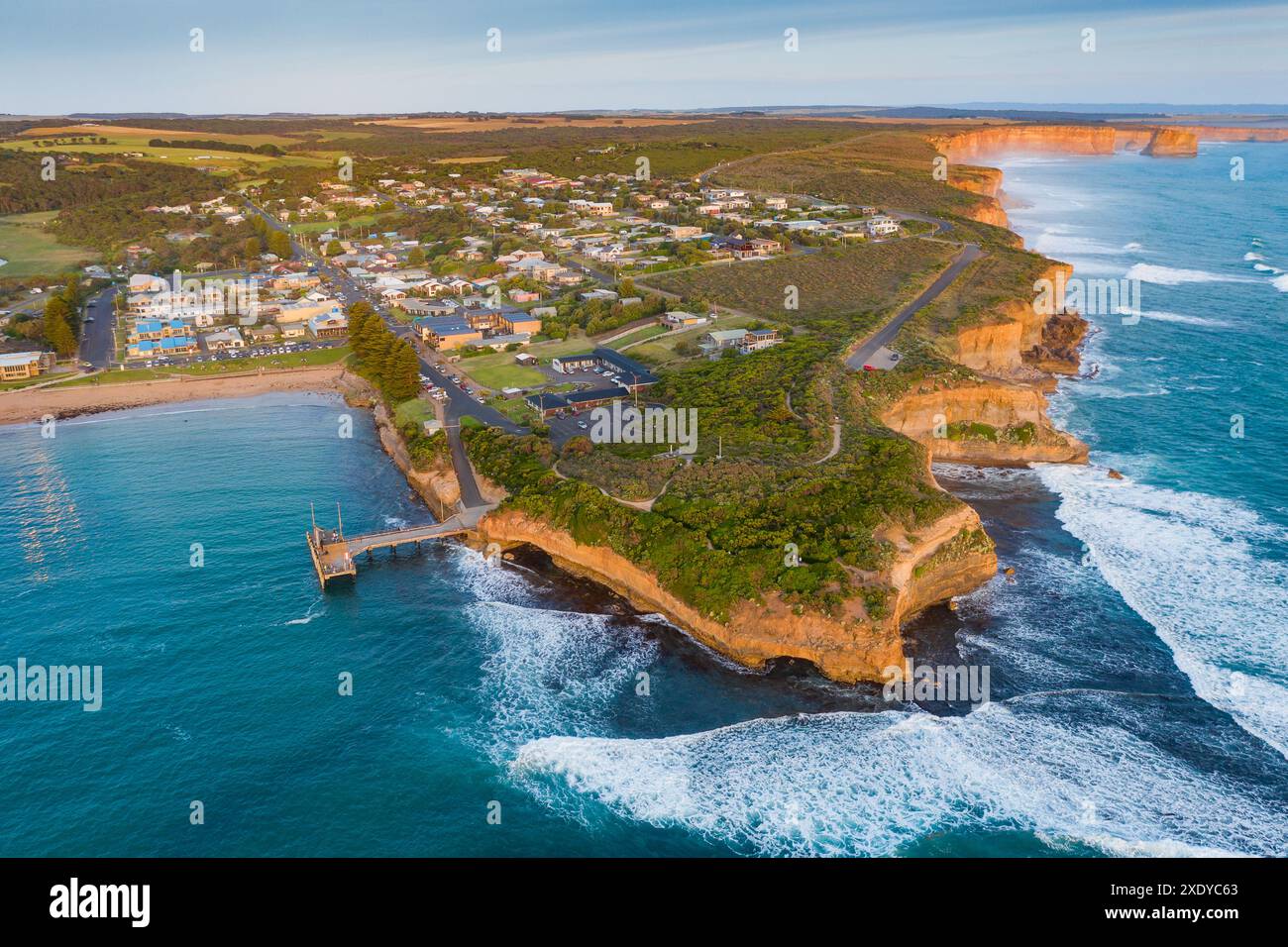 Aerial view of a coastal town around a sheltered bay and high cliffs at ...