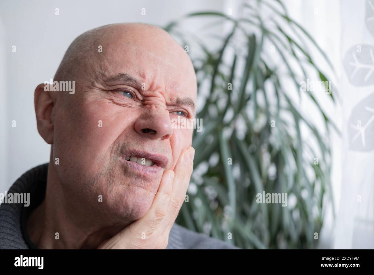 unhappy Senior man, 60, holding painful jaw, agony toothache, pain grimace, suffering from ...