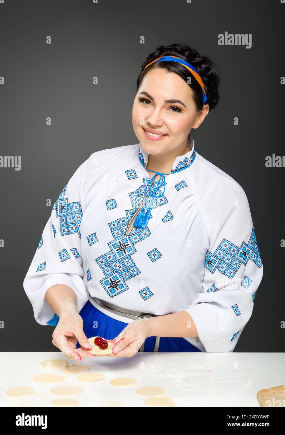 Adult woman in traditional ukrainian style. Cooking ukrainian varenyky ...