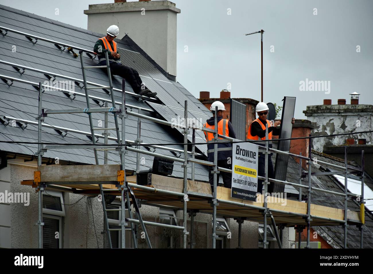 Workers installing solar panels on a roof in Ardara, County Donegal ...