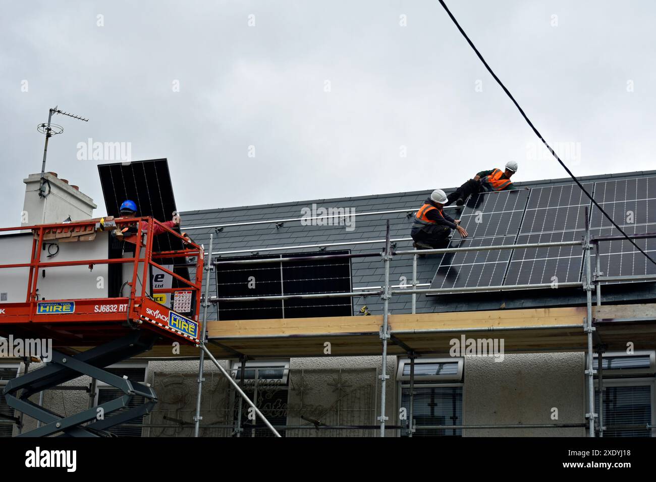 Workers installing solar panels on a roof in Ardara, County Donegal ...