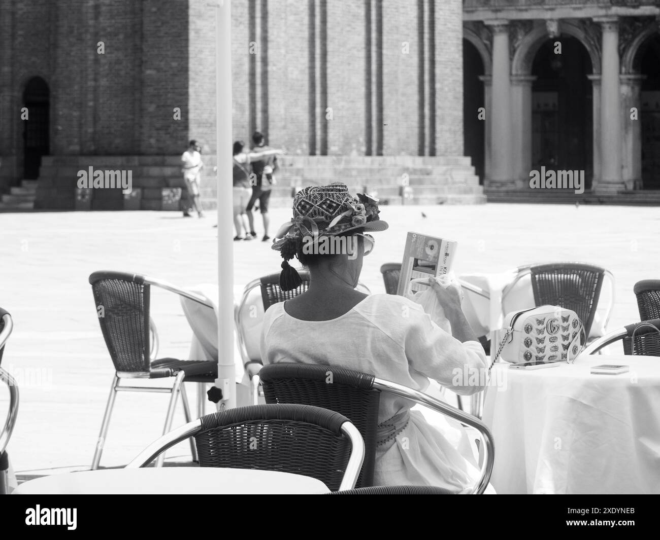 Venice, Italy - June 30th 20220 Woman wearing a hat sitting in a cafe ...