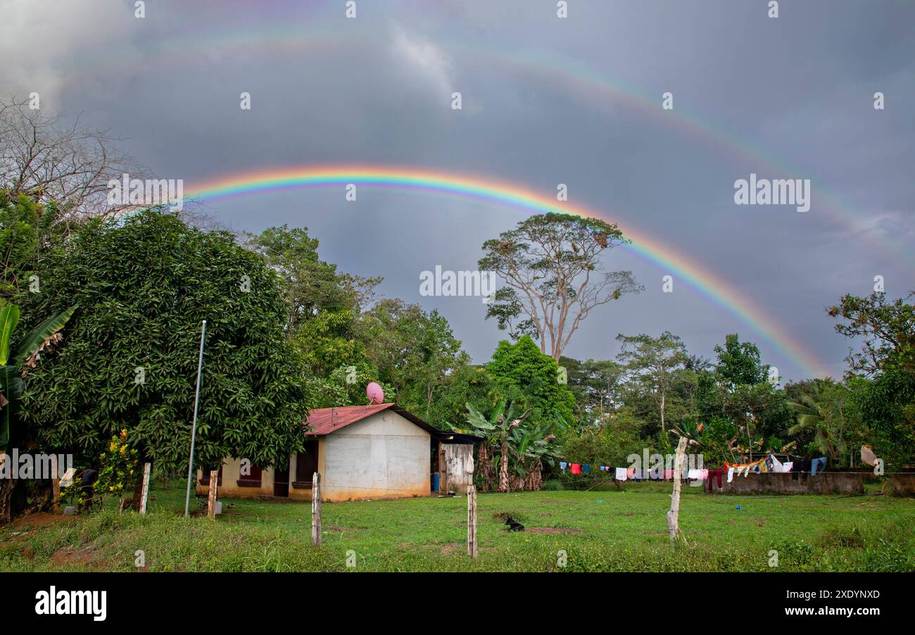 rainbow over farm labourers' house at the edge of the rainforest, Costa ...