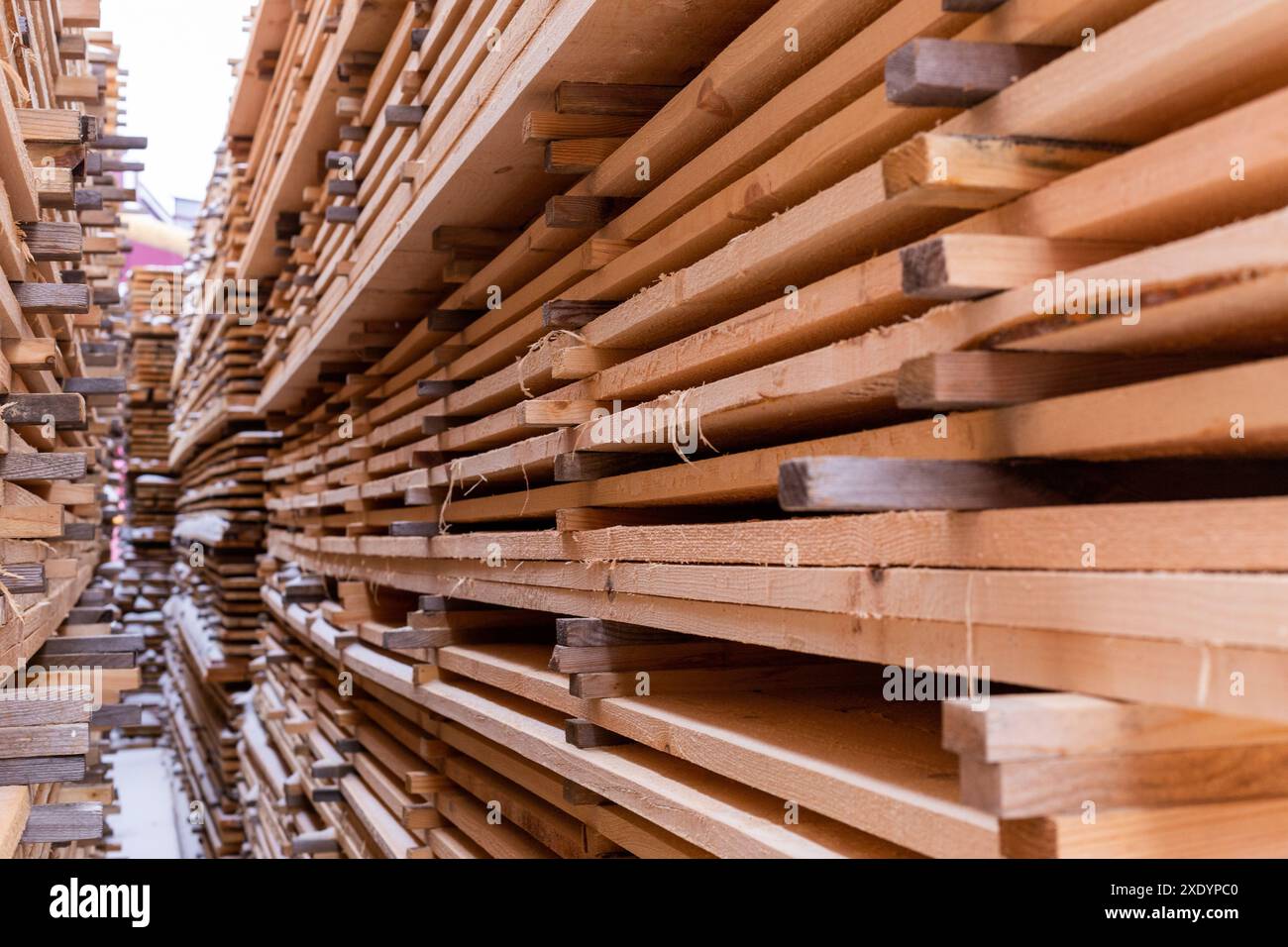 Large stacks of wooden planks background with selective focus and ...